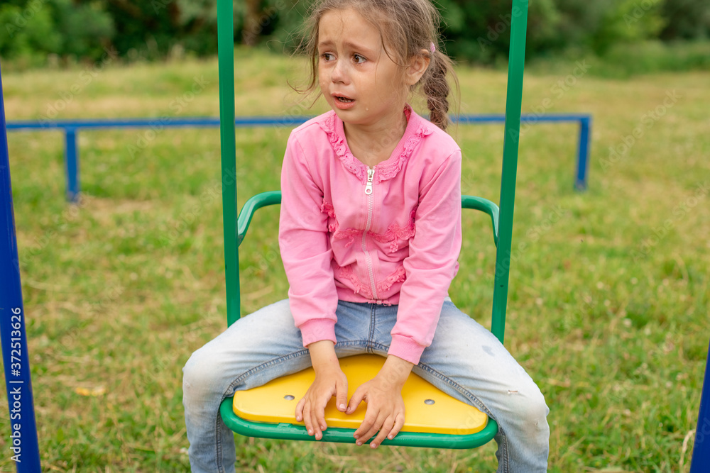 Little girl crying sitting on a swing at the playground Stock Photo ...