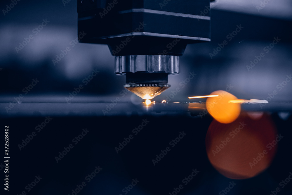 Laser CNC cutting of metal with light spark, modern industrial ...