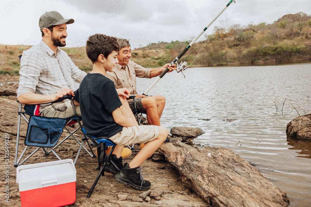 Male members of three generation family fishing together Stock Photo ...