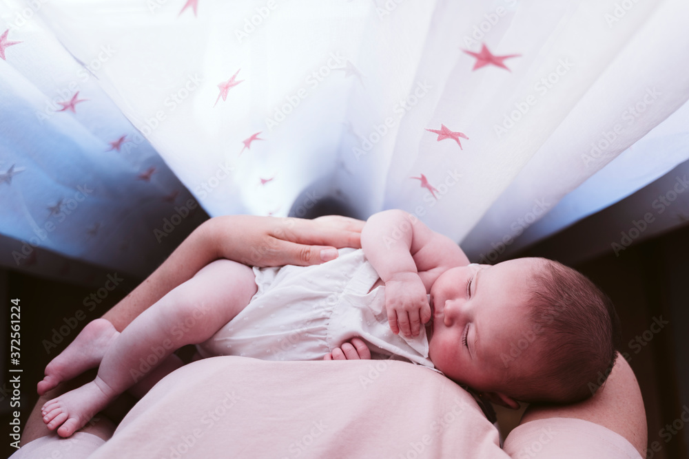 Cute baby girl being carried by mother by window Stock Photo | Adobe Stock