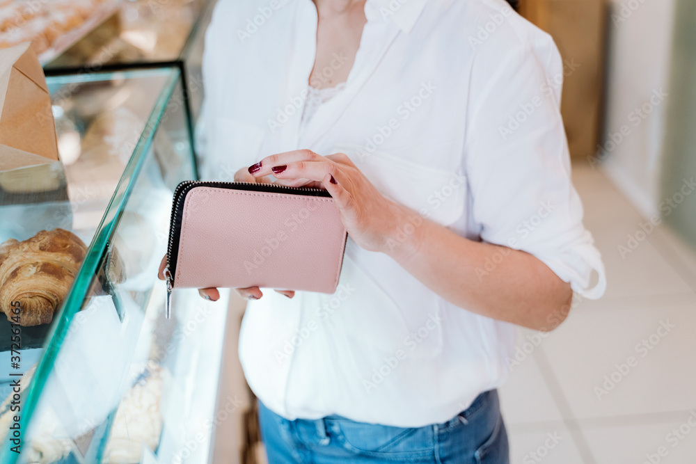 Female customer holding wallet at checkout counter in bakery Stock ...