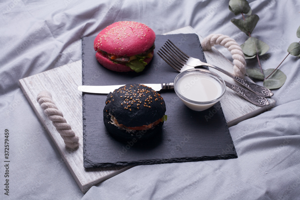 Colorful too mini burgers served on black plate as appetizer. Delicious ...