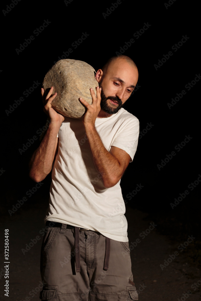 Adult caucasian male carrying a heavy burden Stock Photo | Adobe Stock
