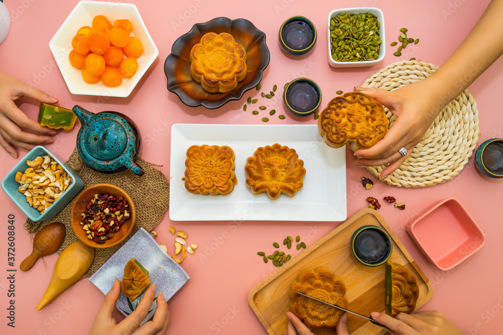 Hands of happy people eating tasty round moon cakes at mid autumn ...