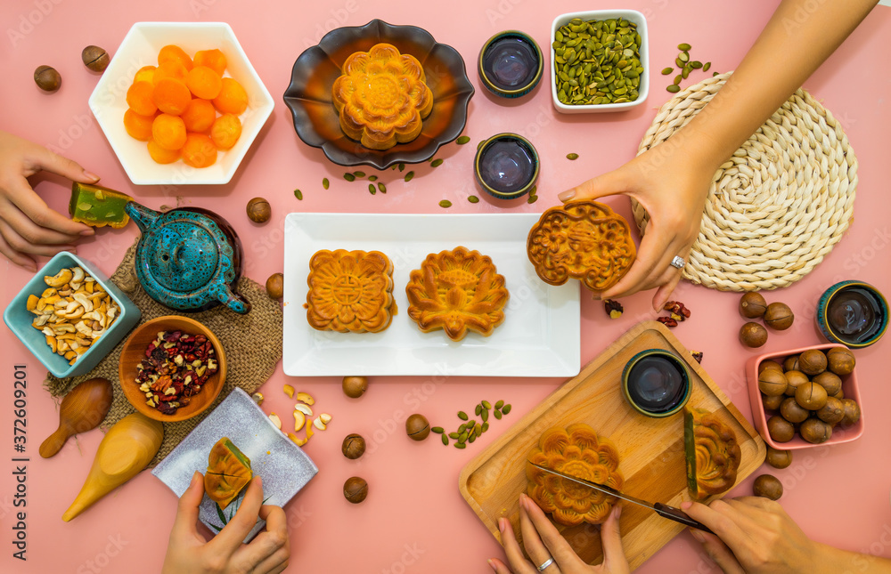 Hands of happy people eating tasty round moon cakes at mid autumn ...