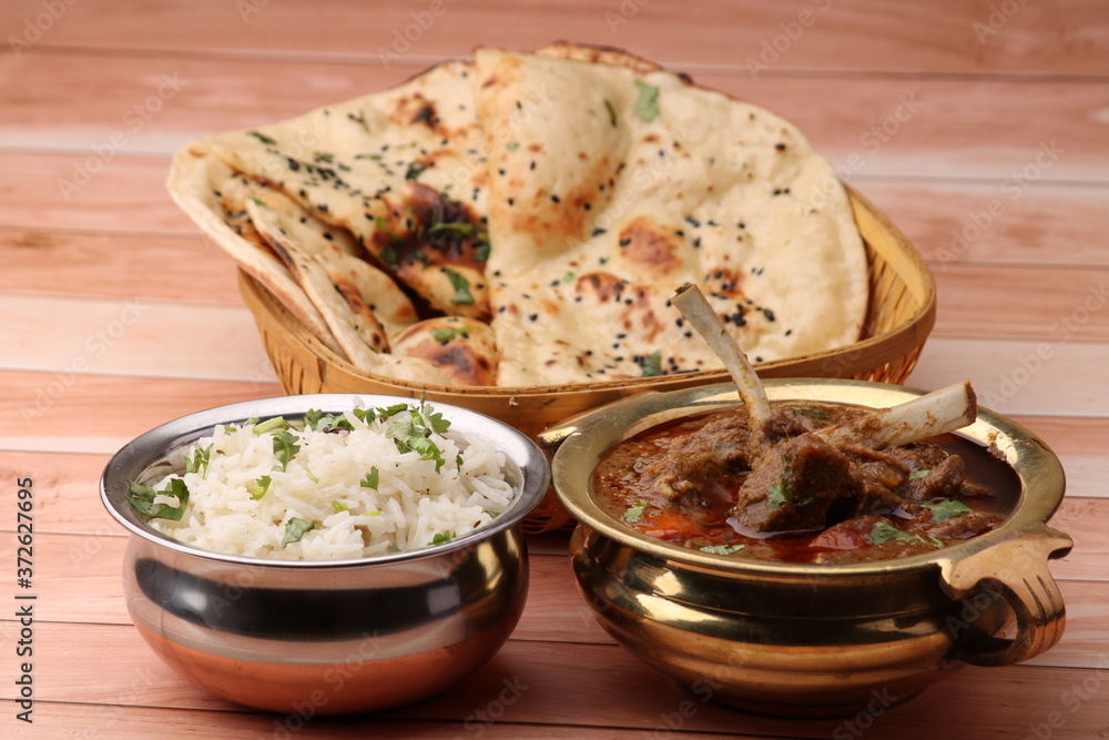 Mutton curry Served with naan or bread and jeera rice over wooden ...