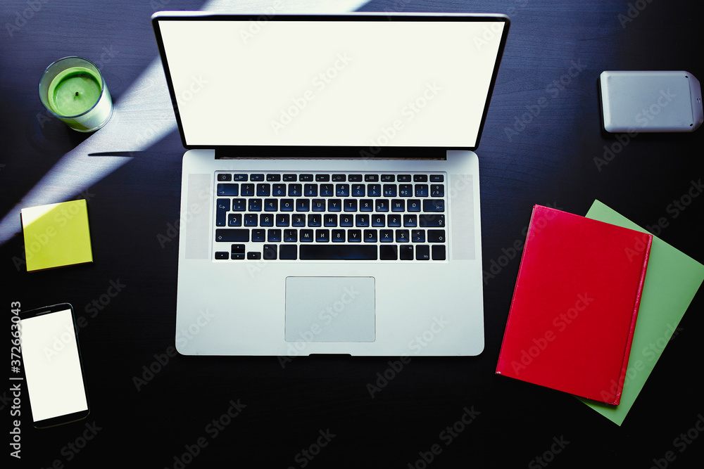 Top view of workplace with open laptop, colorful notebooks and stickers ...