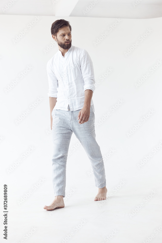 full-length photo in high key on a white background of a handsome ...