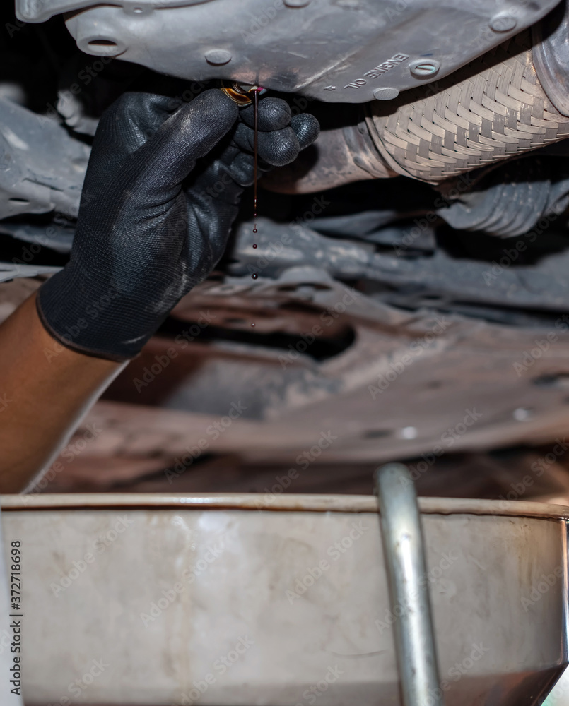 Drain the used gasoline engine oil from the engine sump via drain plug ...