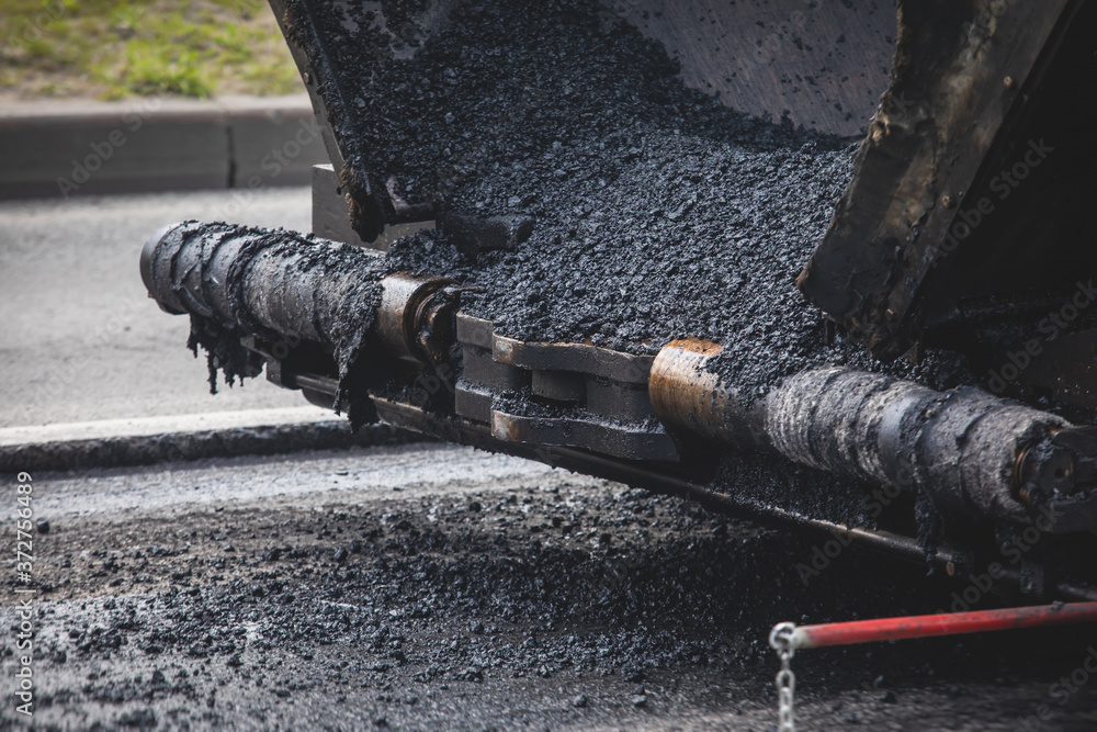 Asphalt paver machine and steam road roller during road construction ...