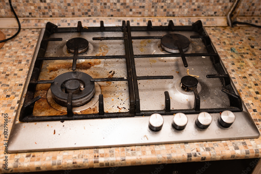 Dirty gas stove stained while cooking, a stove in grease. Unsanitary ...