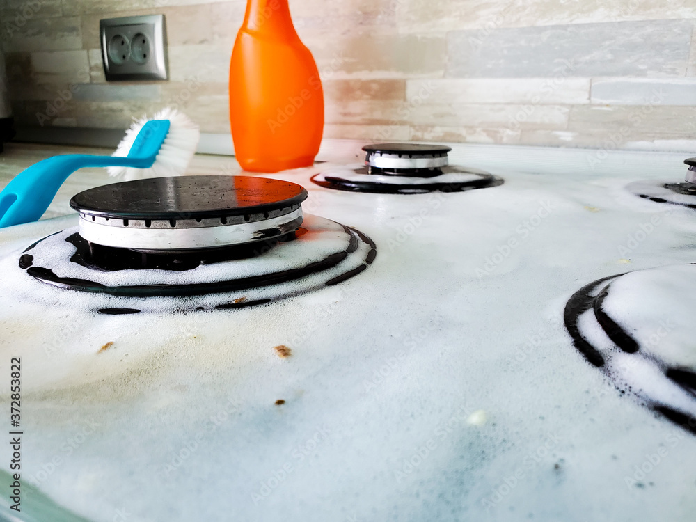 removing fat. Cleaning a dirty gas stove and burner, foam to dissolve ...