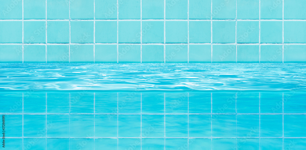 Side view of Blue tiles mosaic wall with water texture in swimming pool ...