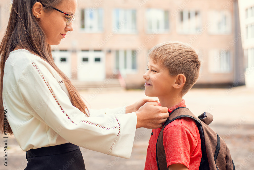 Elder sister helping her small brother in preparation for school ...