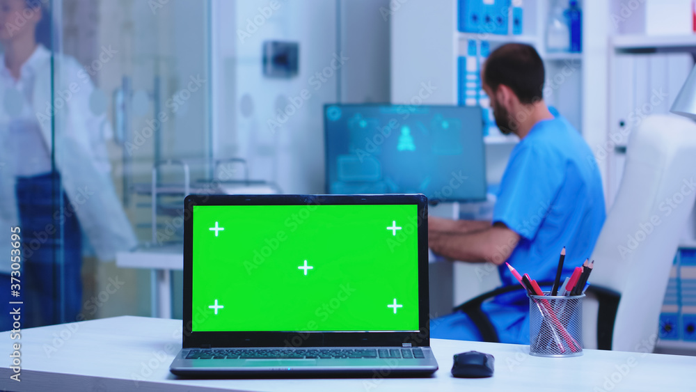 Laptop with replaceable screen in hospital cabinet, doctor wearing coat ...