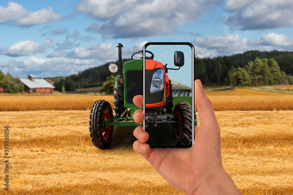 Old tractor on the farm. The farmer points his phone at this and a new ...