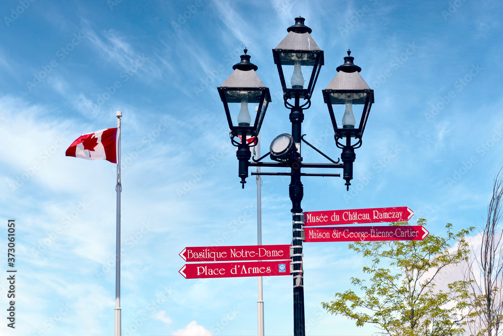 Red arrow street signs mounted on a lamp post with canadian flag in ...