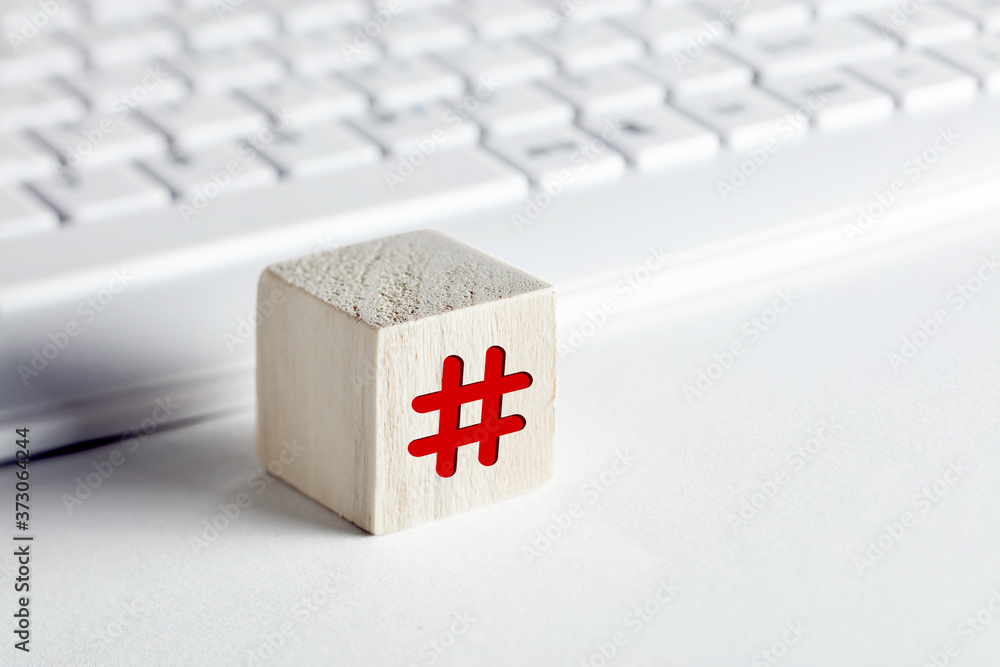 Hashtag symbol on a wooden cube with computer keyboard background on ...
