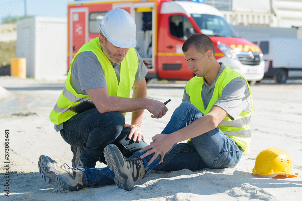 young construction worker on site with injured ankle Stock Photo ...