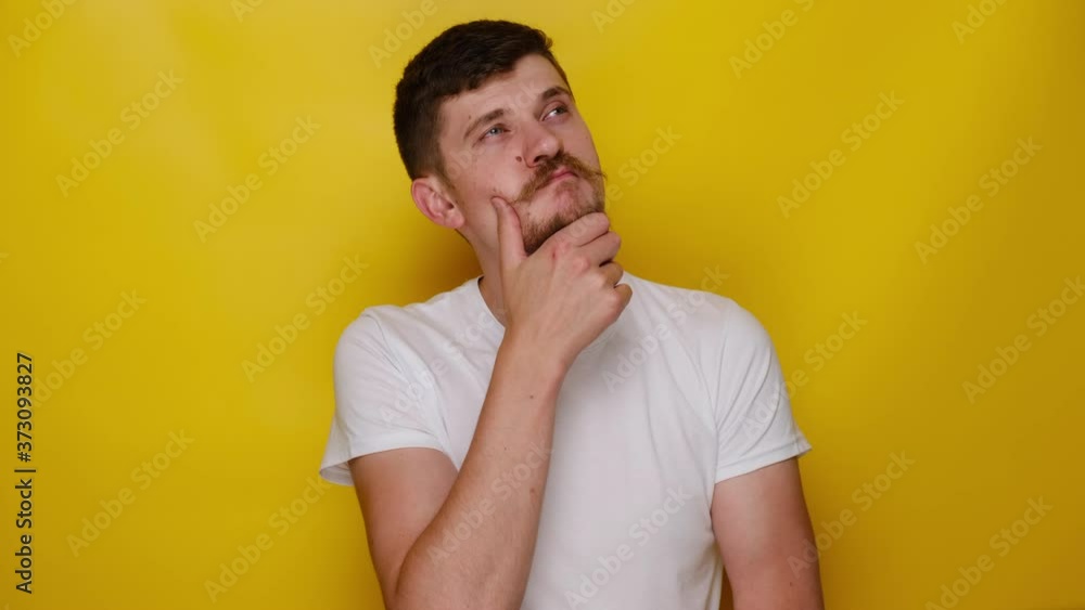 Portrait of thoughtful confused young man touching chin, scratching ...