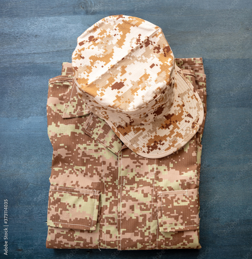 US army cap on a folded uniform, blue color background. Stock Photo ...