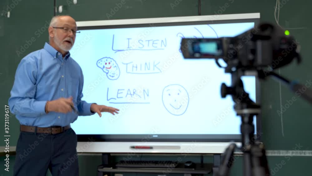 Focus shift from video camera to teacher as very animated male teacher ...
