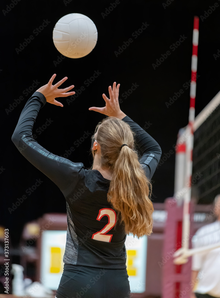 Girl athletes playing volleyball during Covid-19, wearing masks for ...