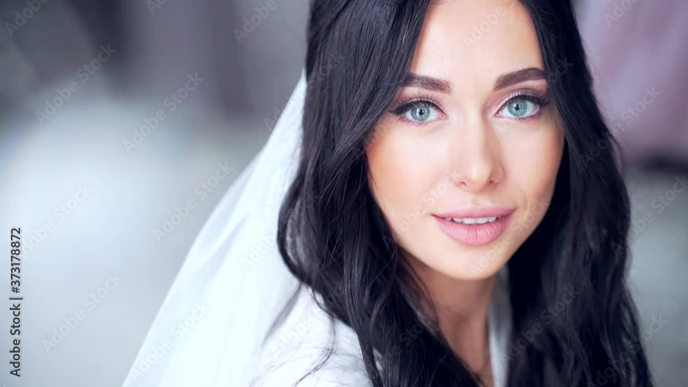 Portrait of a beautiful and attractive bride with black hair and blue ...