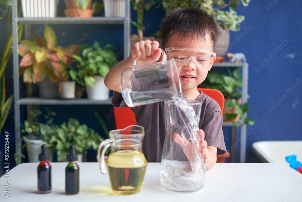 Happy little Asian school kid studying science, making DIY Lava Lamp ...