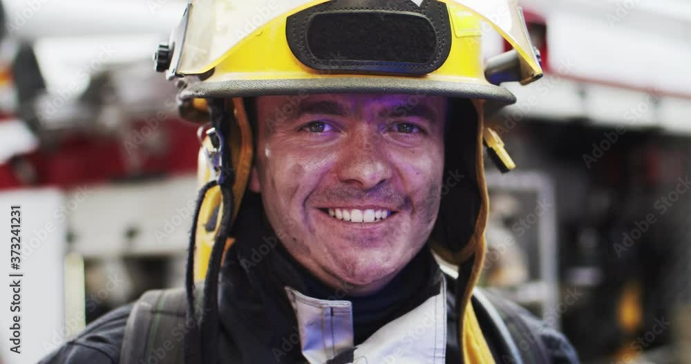 Close up portrait of happy smiling fireman in helmet and gull equipment ...