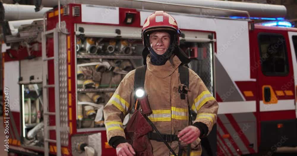 Middle plan of happy fireman in helmet and gull equipment cross arms ...