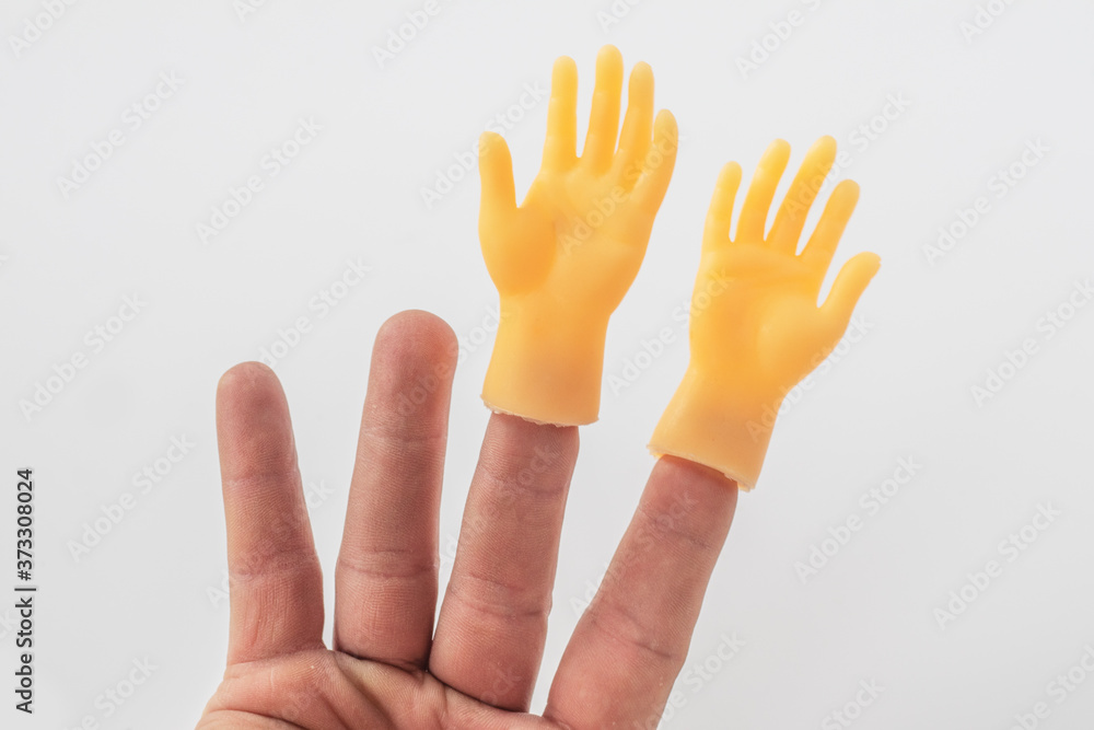 Hand on a white background on her fingers is wearing a toy in the shape ...