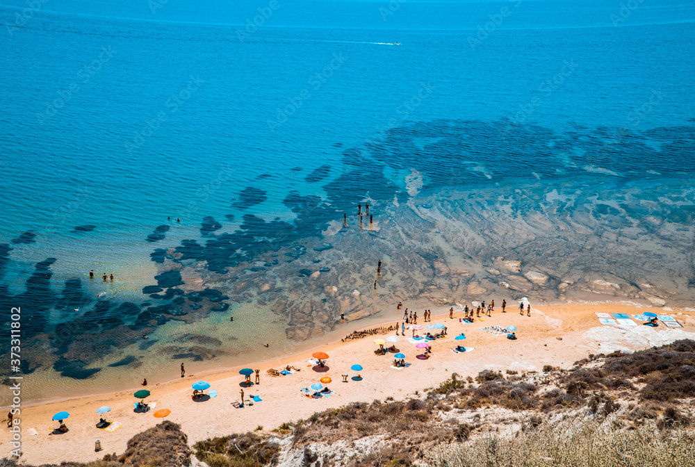 The amazing beach with different shades of blue waters, swimmers and ...