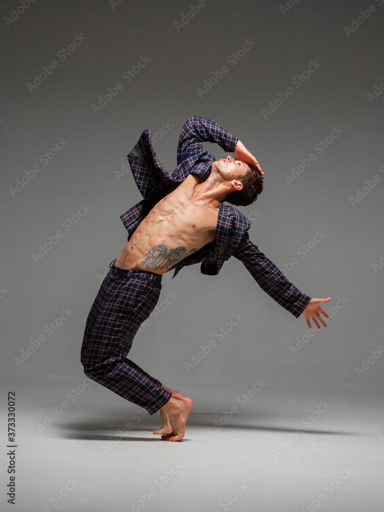 Handsome young guy dancer in suit and barefoot dancing expressive dance ...