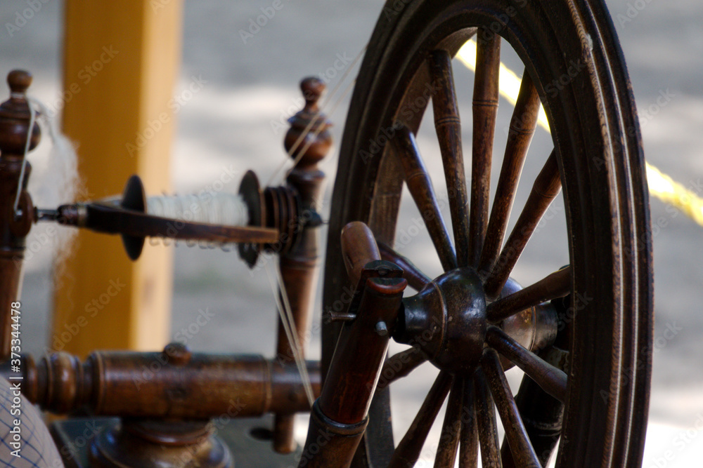 Old lady spinning yarn on spinning-wheel Stock Photo | Adobe Stock