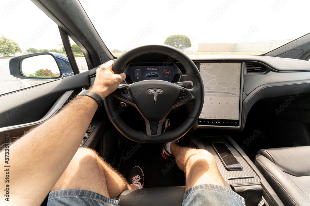 Person driving a new Tesla SUV. The interior of a full-sized, all ...