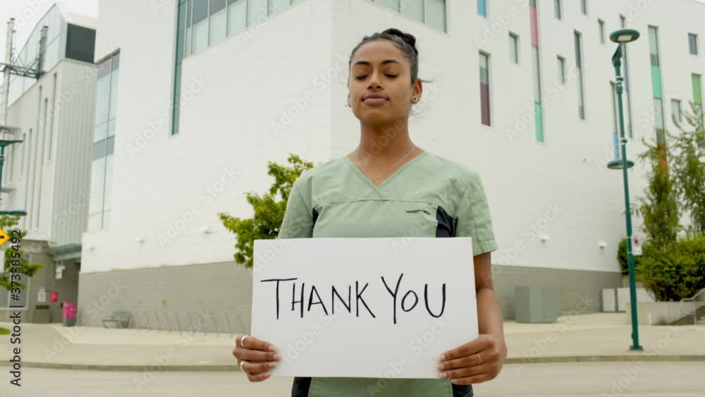 Indian woman, POC, nurse doctor wearing medical uniform stands in front ...