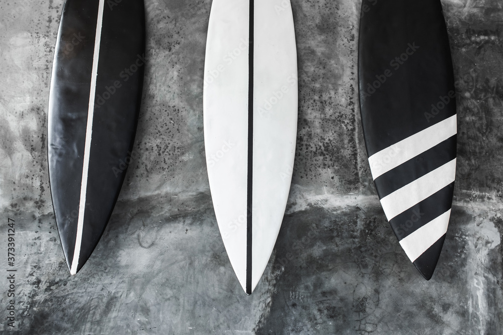 Black and white color surf board on gray concrete wall background ...