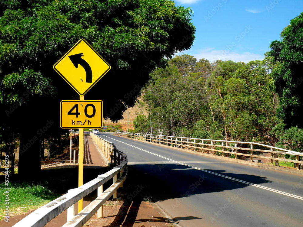 Left curve ahead sign and speed limit sign Stock Photo | Adobe Stock