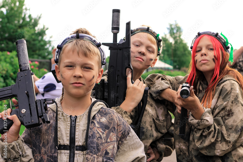 Children playing in lasertag shooting game in open air. Weapon in the ...