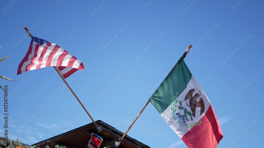 Mexican tricolor and American flag waving on wind. Two national icons ...