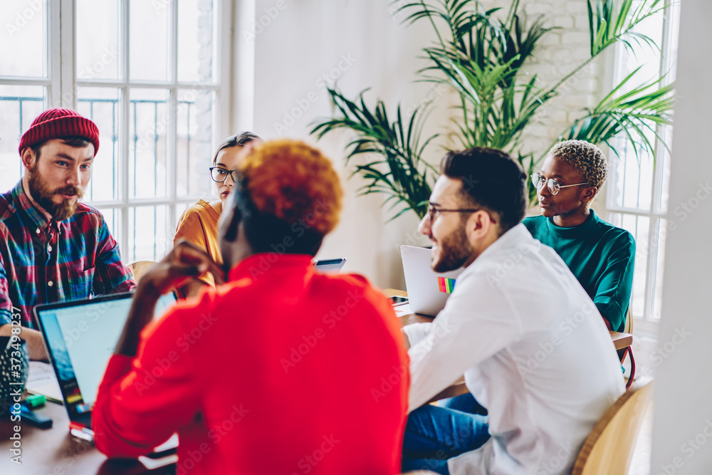 Millennial male and female graphic designers talking about project ...