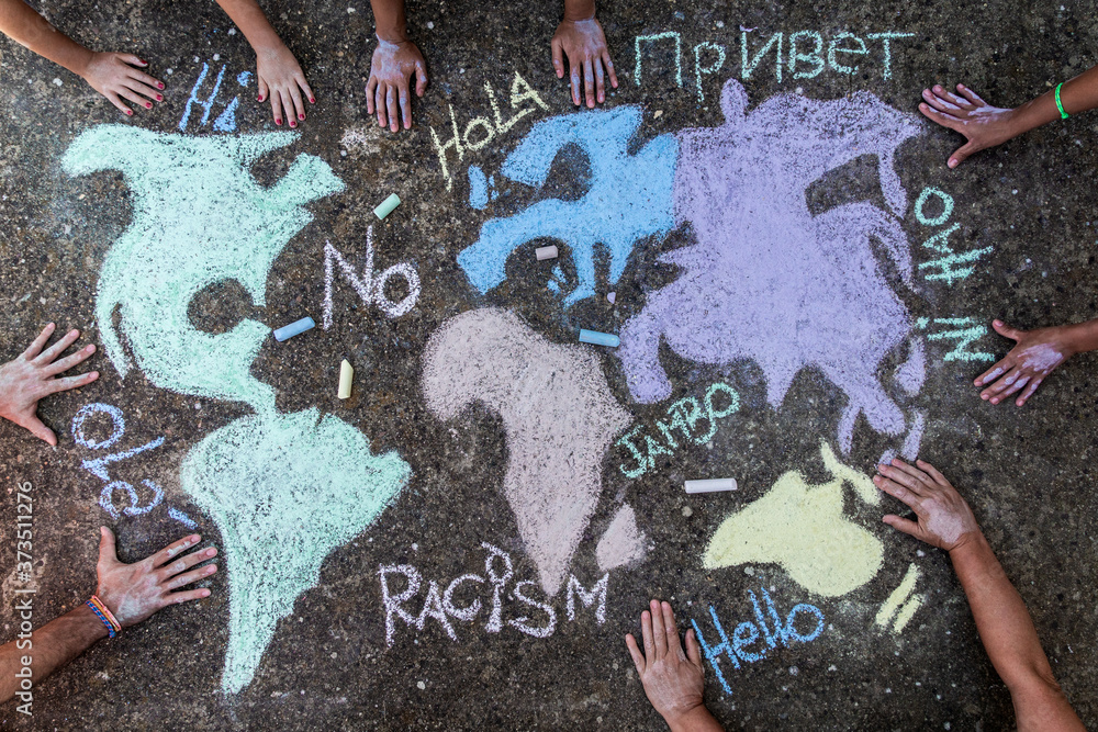 A group of people drawing with colored chalks on the floor with his ...