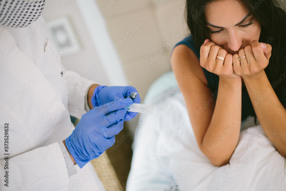 The female doctor in protective equipment a mask, gloves performs the ...