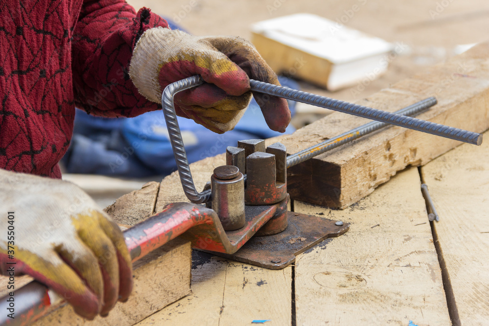 Bending reinforcement metal rebar. Worker using bending rebar machine ...