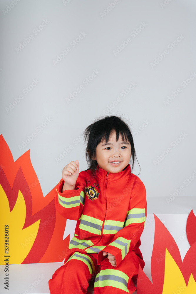 Little girl role play as a firefighter. Stock Photo | Adobe Stock