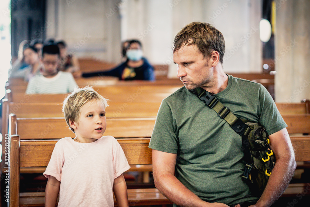 Christian dad tells his son Bible stories about Jesus sitting in kirk ...