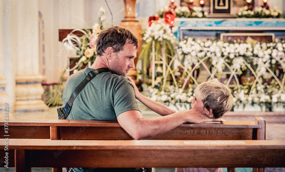 Christian dad tells his son Bible stories about Jesus sitting in kirk ...