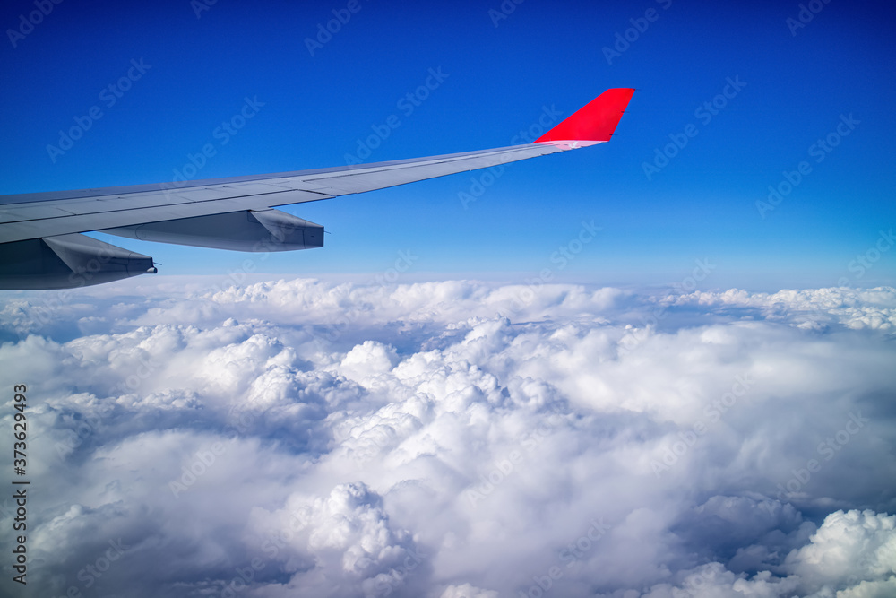 Airplane wing and aerial view during flight with clear blue sky and ...