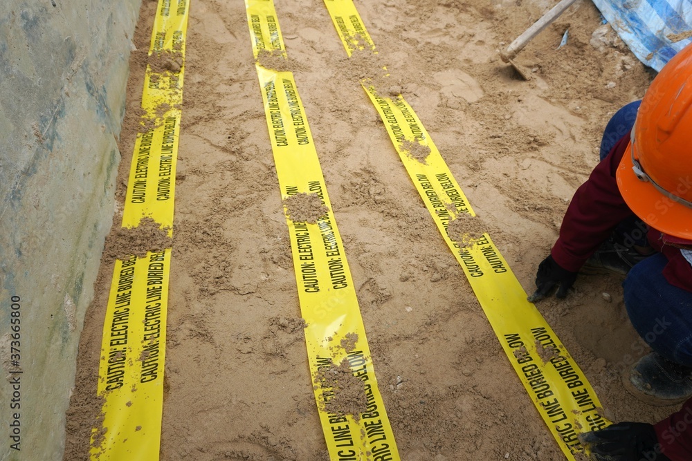 Underground warning tape placed on the sand to alert the underground ...